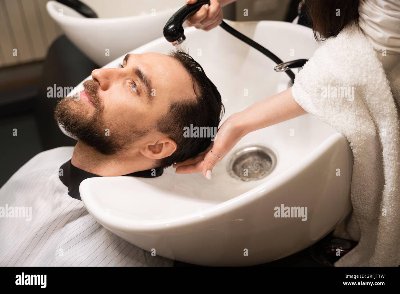 Client enjoys the procedure of washing hair in the barbershop Stock ...