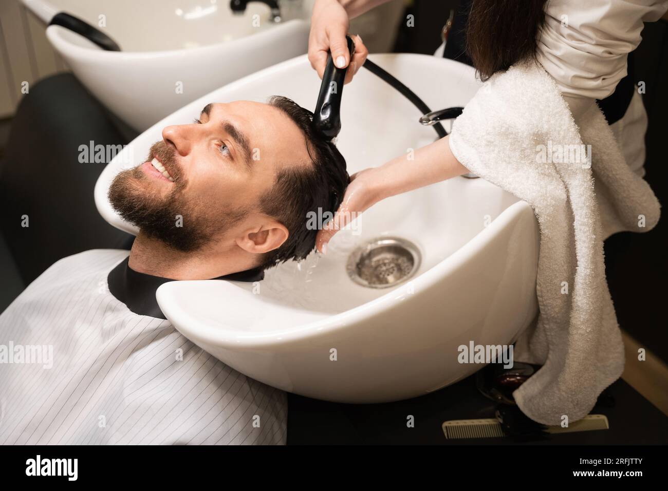 Client enjoys washing his hair in the barbershop Stock Photo - Alamy