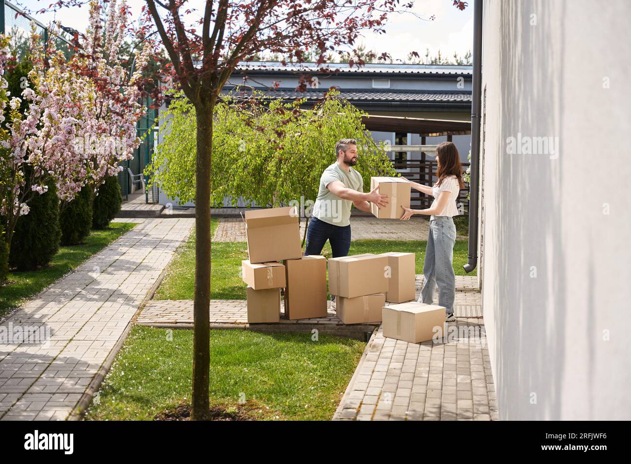 Young loving couple laying out boxes outside Stock Photo - Alamy