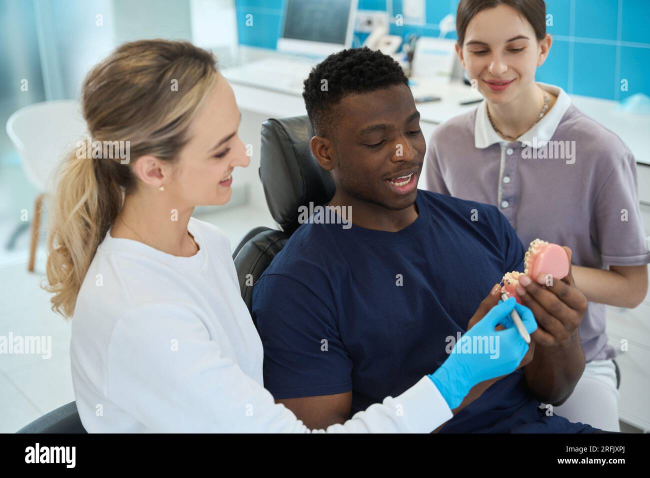 Dentist explaining to client process of teeth treatment Stock Photo - Alamy