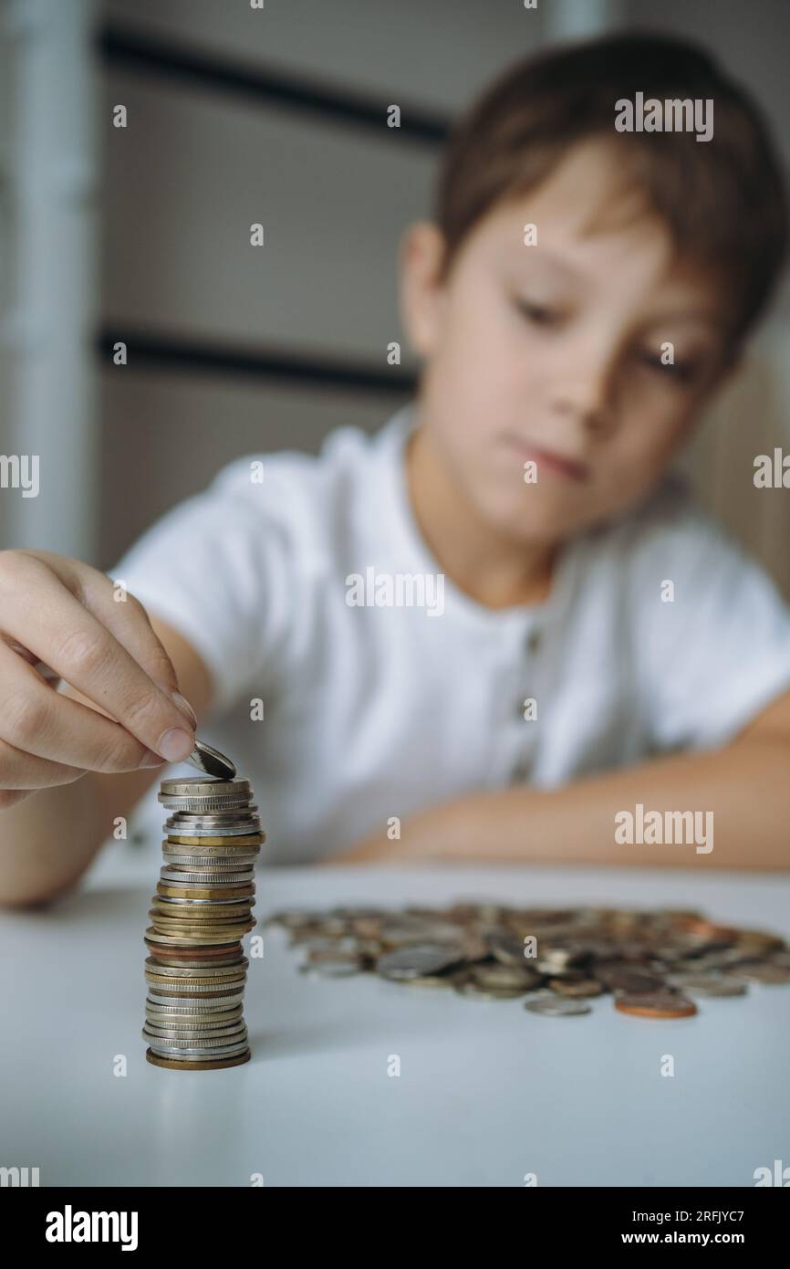 boy making pyramide of coins. ABC of finance. boy counting money. Image ...