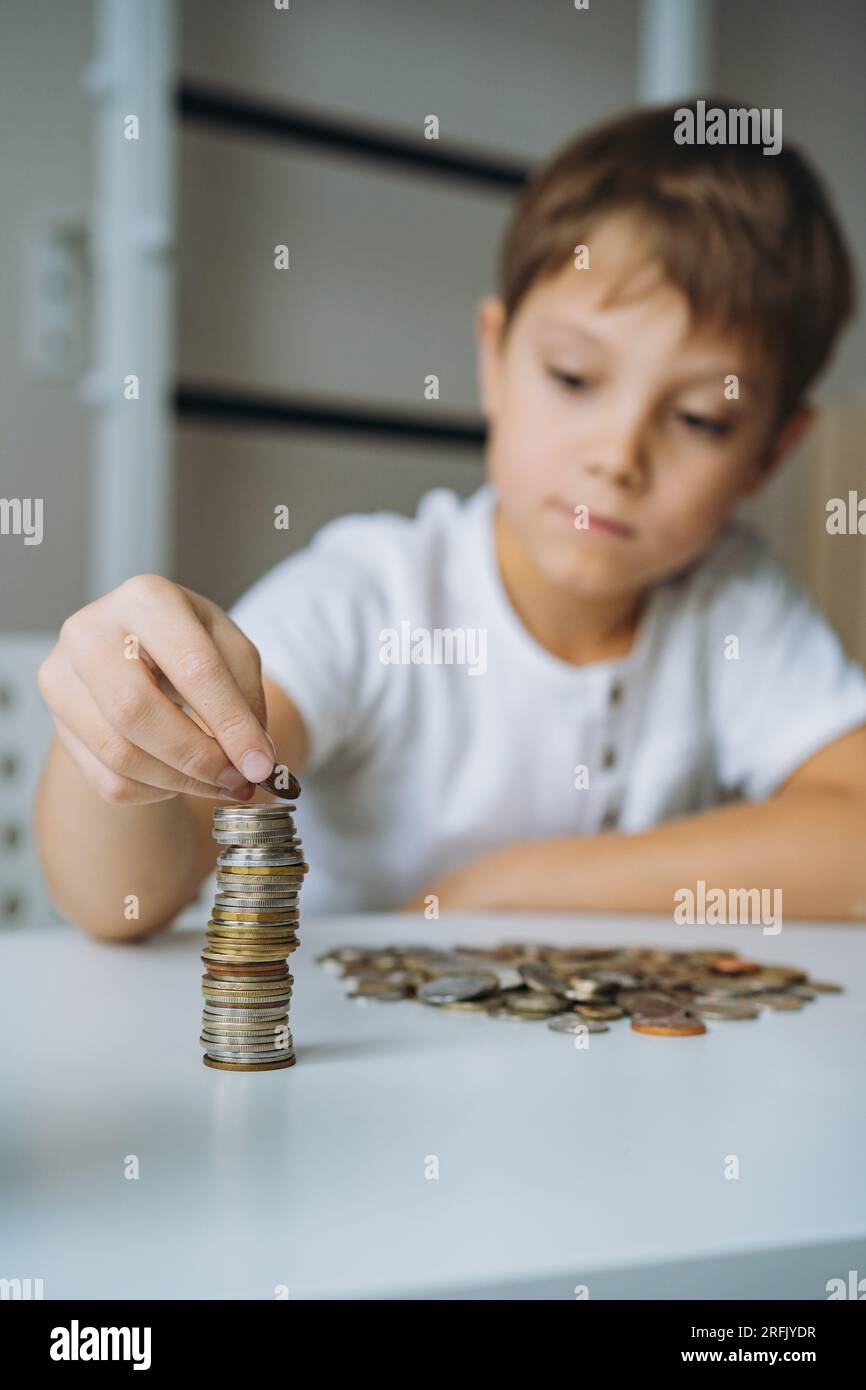 boy making pyramide of coins. ABC of finance. boy counting money. Image ...