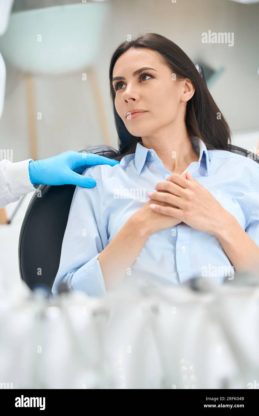Woman feeling nervous sitting in comfortable chair at the doctor's ...