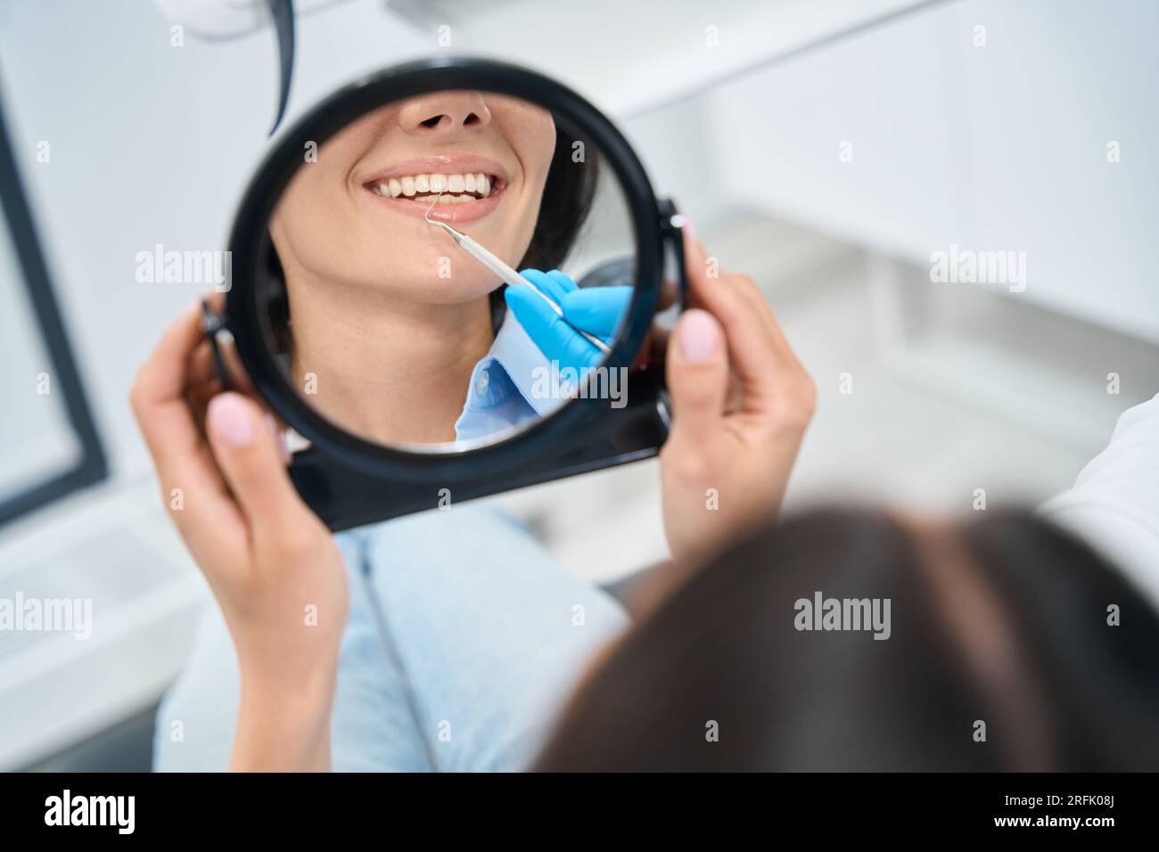 Dentist using sickle probe to show to woman patient problem area Stock ...