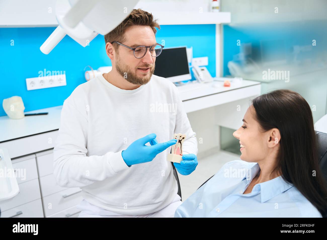 High-qualified stomatologist explaining build of tooth on 3d model ...