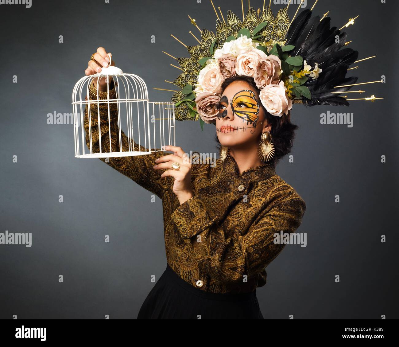 Portrait of woman in sugar skull makeup holding a cage . Halloween and ...