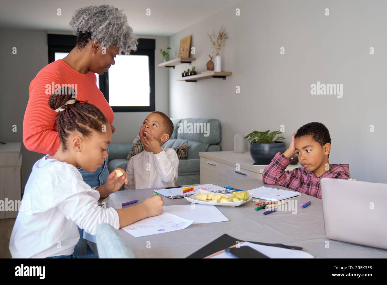 African family having a snack while painting or doing the homework ...