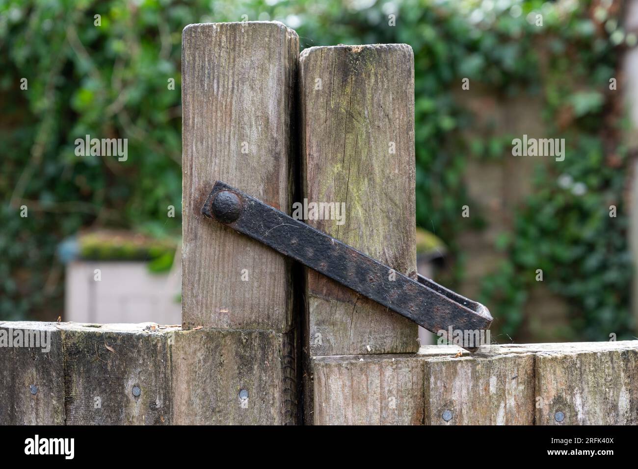 Old wooden gate with metal hinge lock, traditional style and common in ...