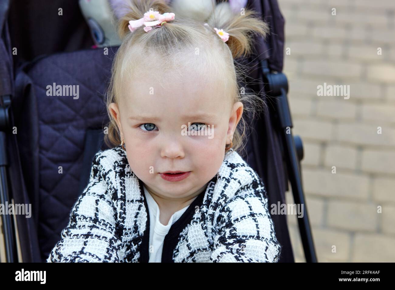 Baby in stroller on a walk in summer park. Adorable little girl sitting ...