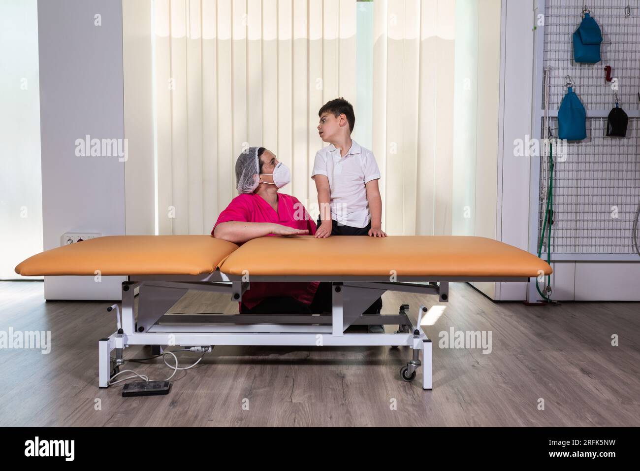 a female physical therapist (doctor, physician, nurse) observes her ...