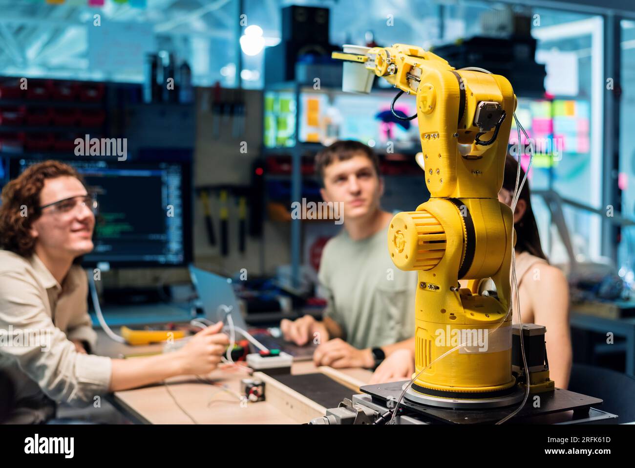Group of young people doing experiments in robotics in a laboratory ...