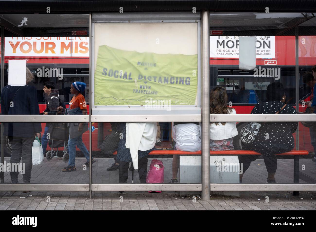 Passengers wait for the next bus service to arrive where a faded Covid ...