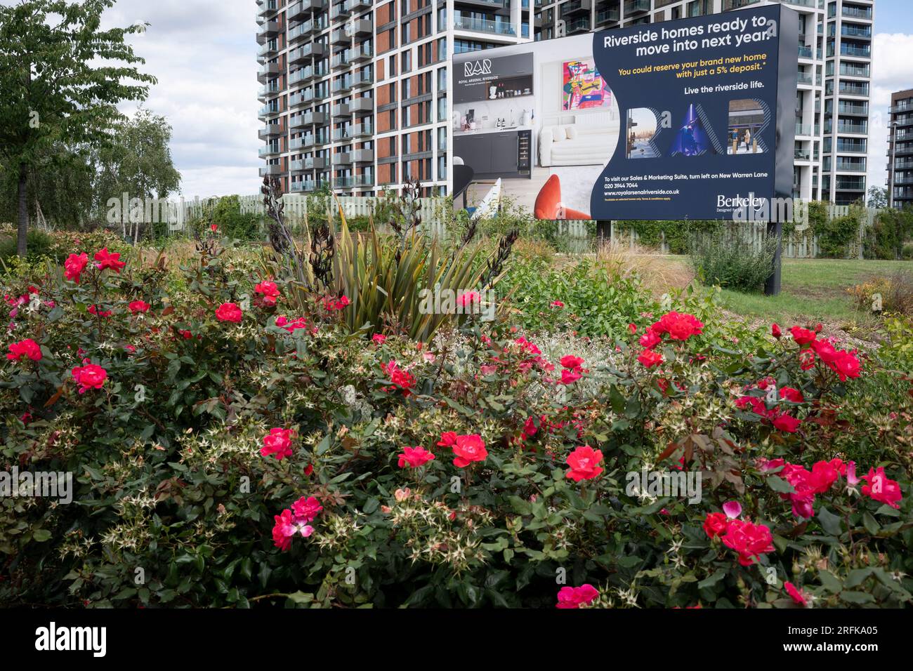 Landscaped shrubs and flowers in front of a sign advertising future ...
