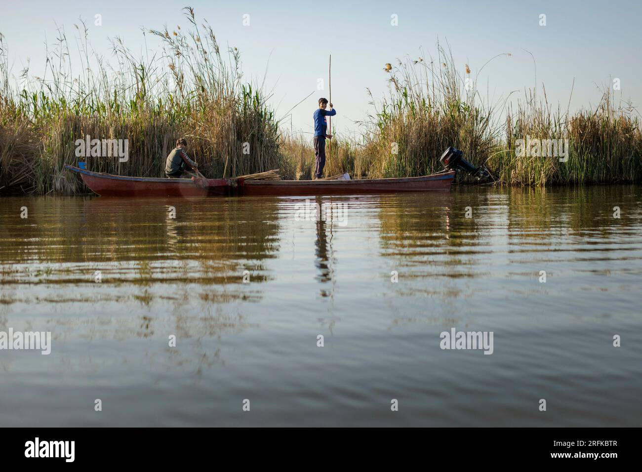 Boat with two young men in the world heritage marshland, in Basra ...