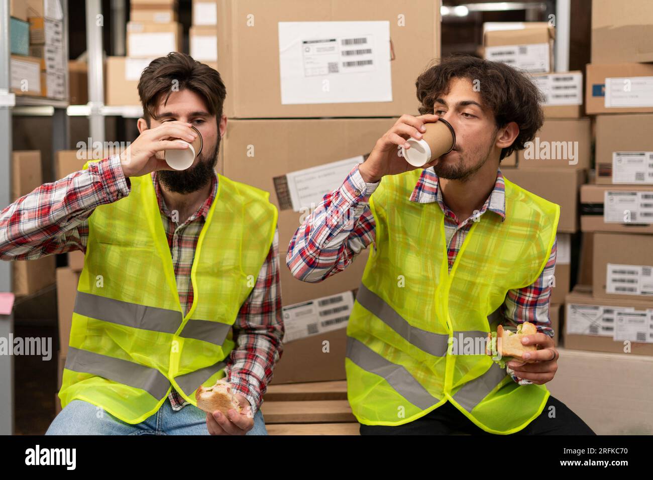 Two warehouse workers have coffee break and lunch break Stock Photo - Alamy