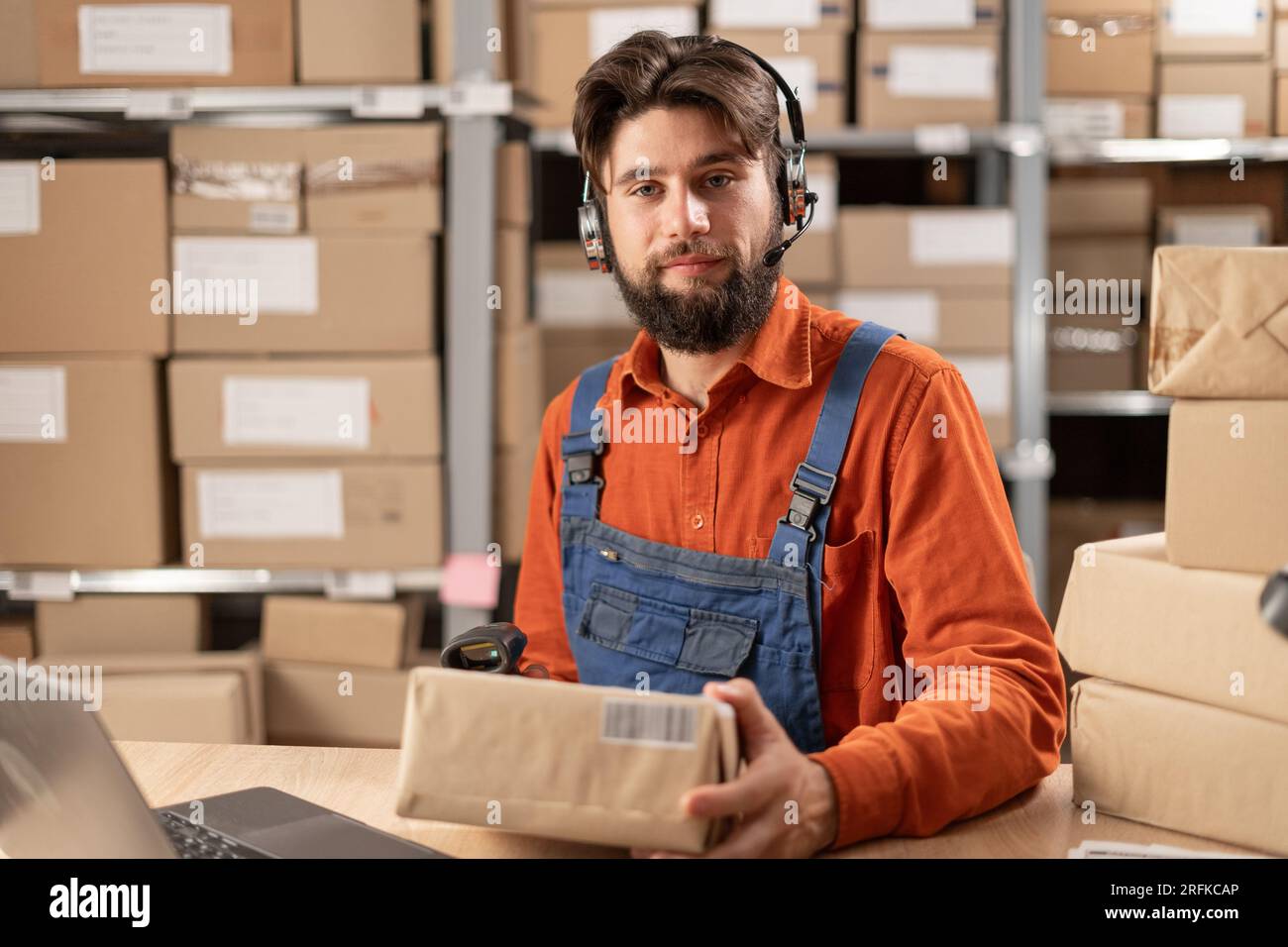 Delivery service man talking on voice picking headset and holding order ...