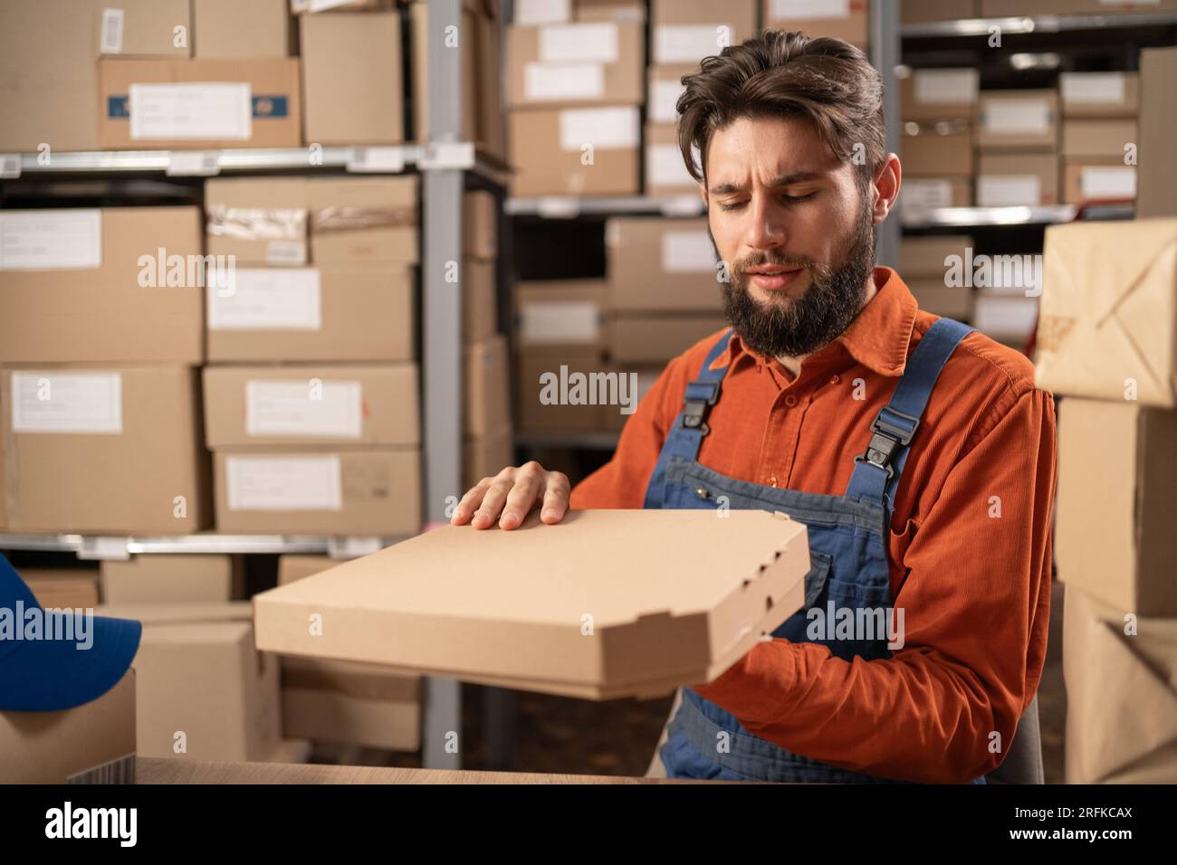 Italian pizza delivery. Happy warehouse worker opening pizza box Stock ...