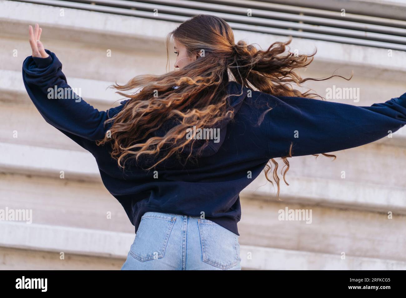 Gorgeous Girl Dancing Backwards Next To A Concrete Wall Stock Photo - Alamy