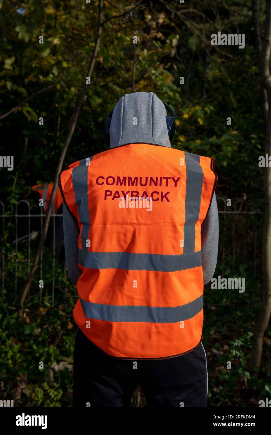 A community payback group are clearing an overgrown piece of land Stock ...
