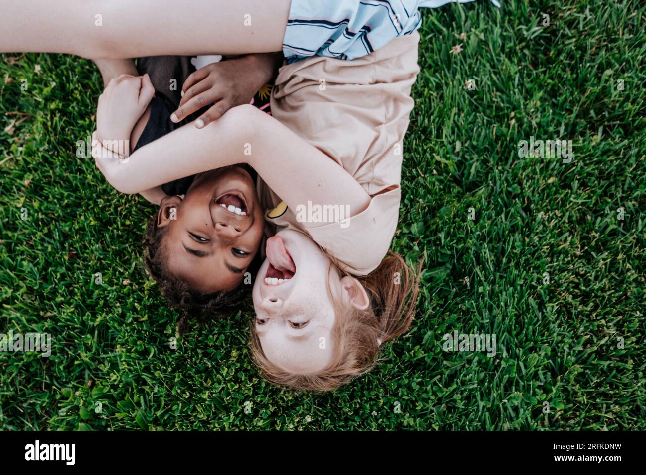 Children laying in grass being silly Stock Photo - Alamy
