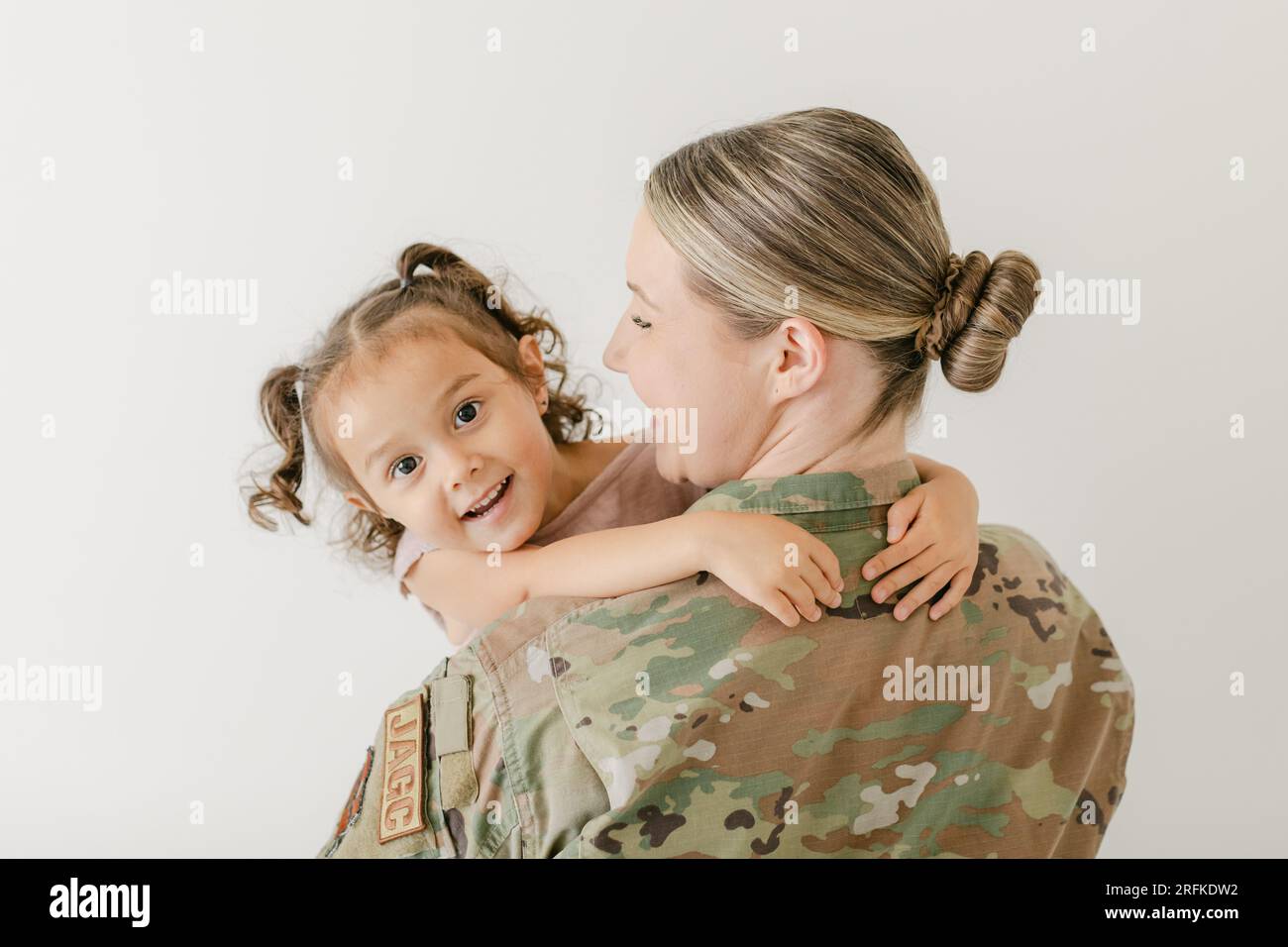 girl peeks around military mom in uniform to smile Stock Photo - Alamy