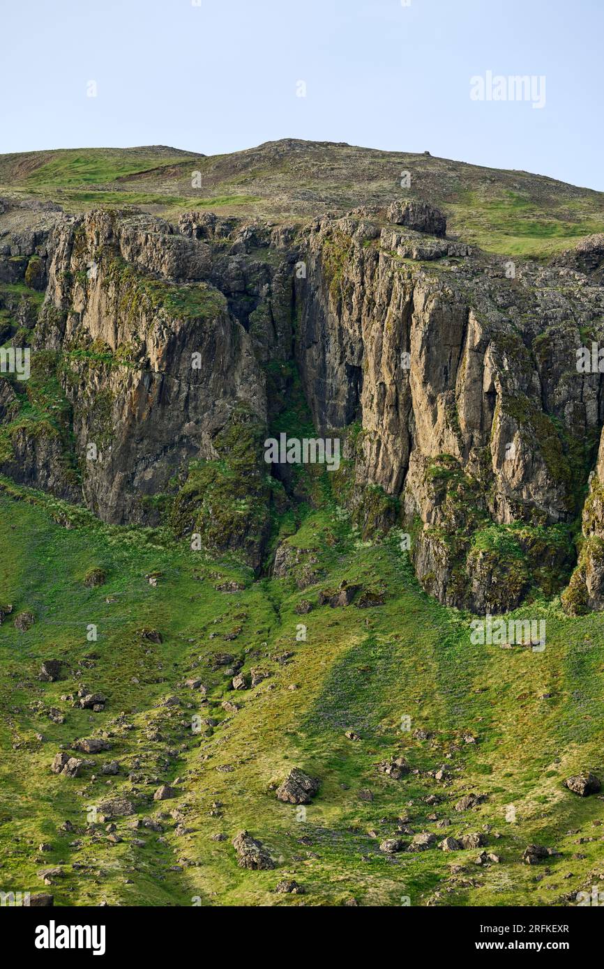 Landscape with rocky formations and slope with green grass Stock Photo ...