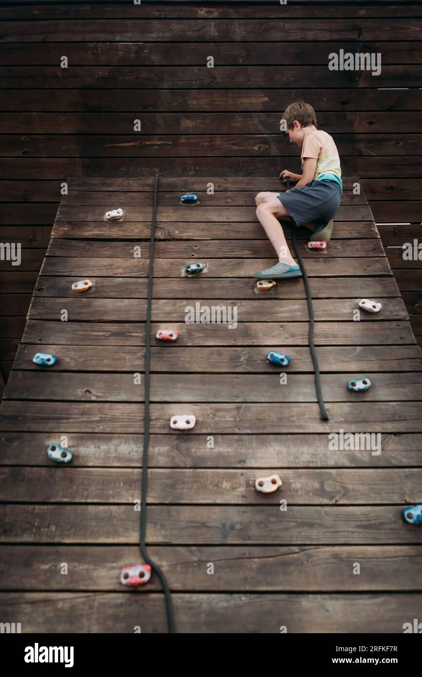 Child climbing rock wall on playground with on summer day Stock Photo ...