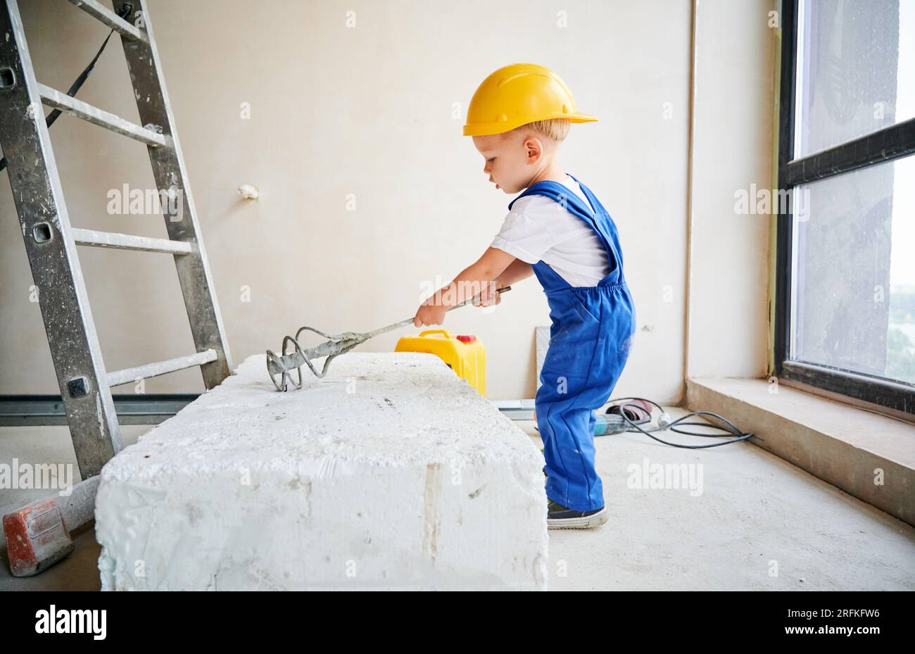 Full length of little boy construction worker using building instrument ...