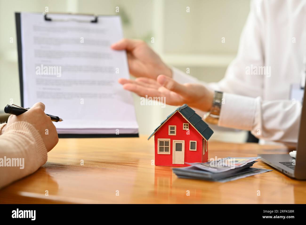 Male realtor explaining contract details to clients at meeting ...