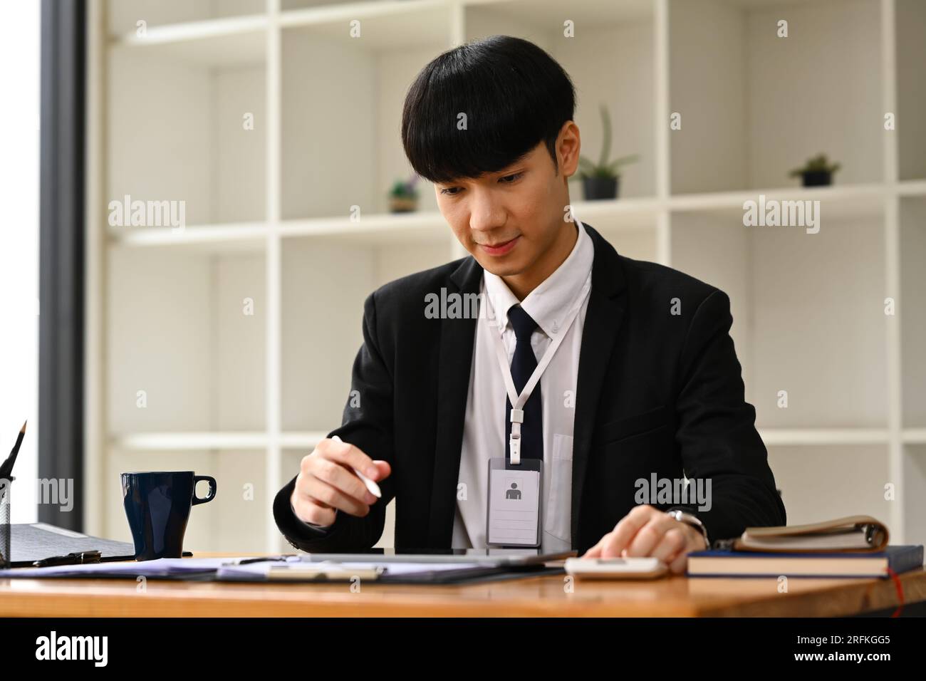 Asian male manager wearing black suit hand filling paper business ...