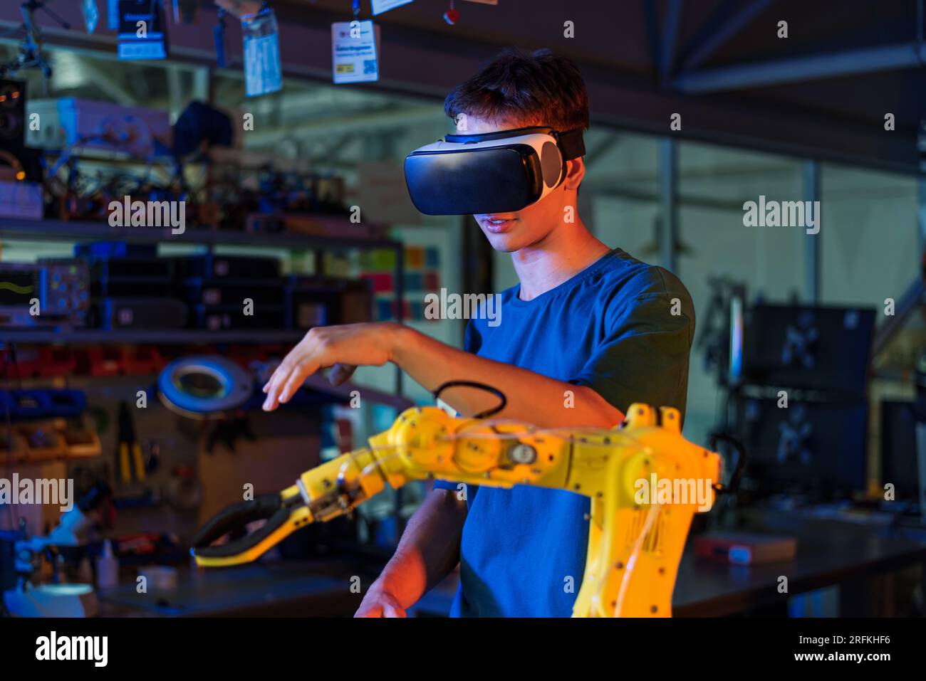 Teen doing experiments in robotics in a laboratory. Boy in VR headset ...