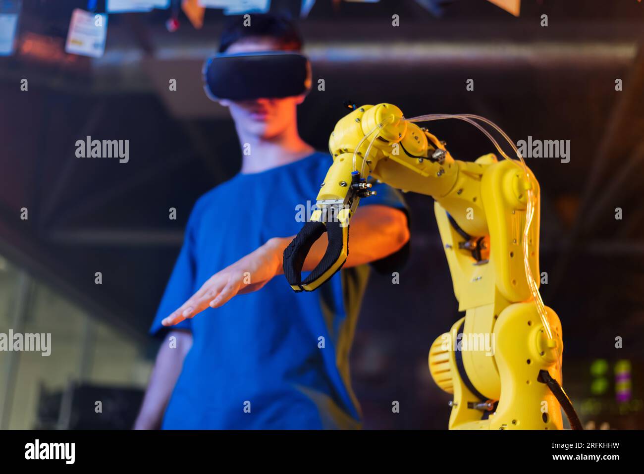 Teen doing experiments in robotics in a laboratory. Boy in VR headset ...
