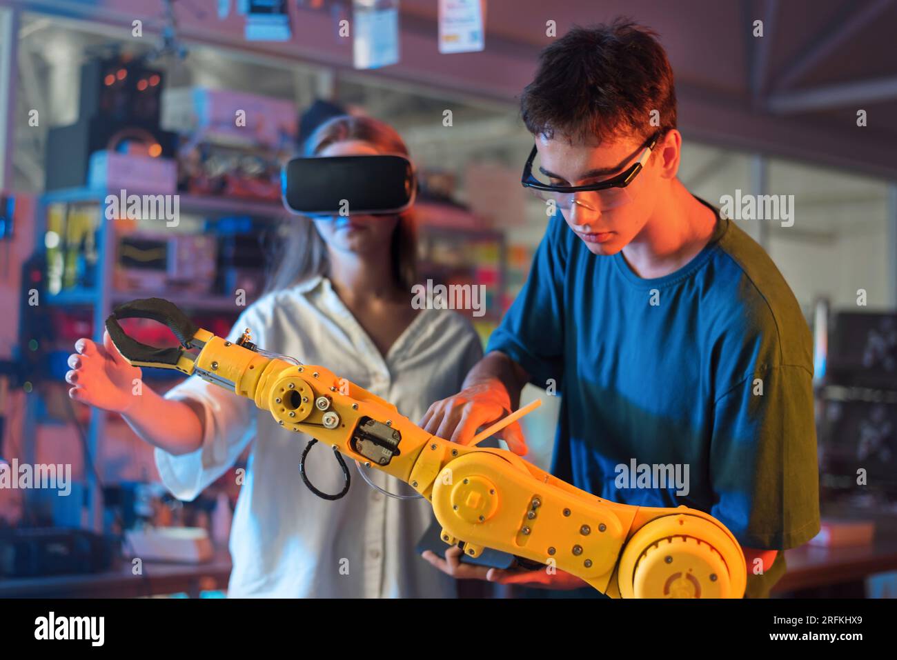 Teens doing experiments in robotics in a laboratory. Boy in protective ...