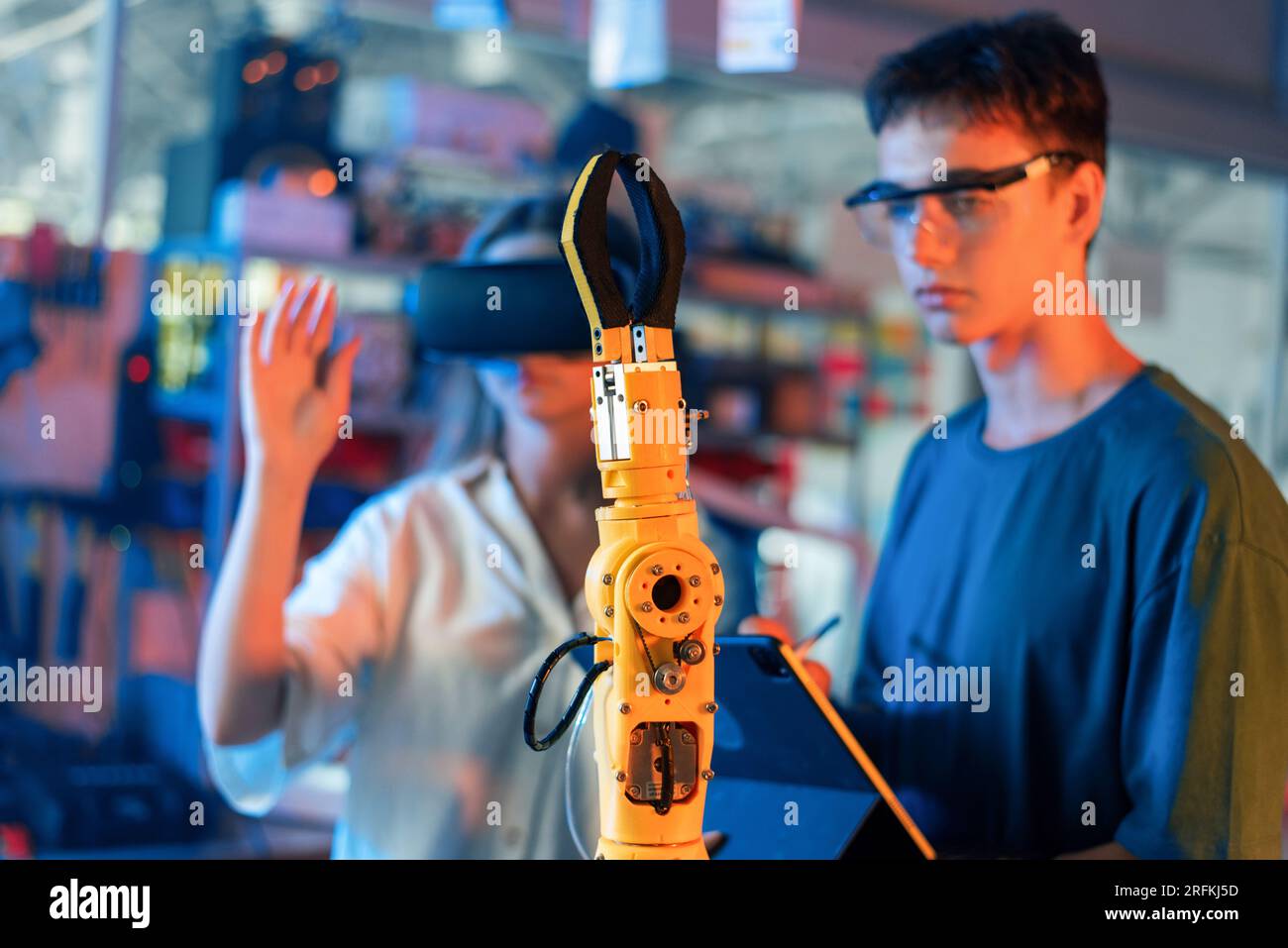 Teens doing experiments in robotics in a laboratory. Boy in protective ...