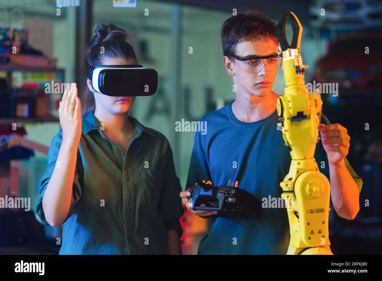 Teens doing experiments in robotics in a laboratory. Boy in protective ...