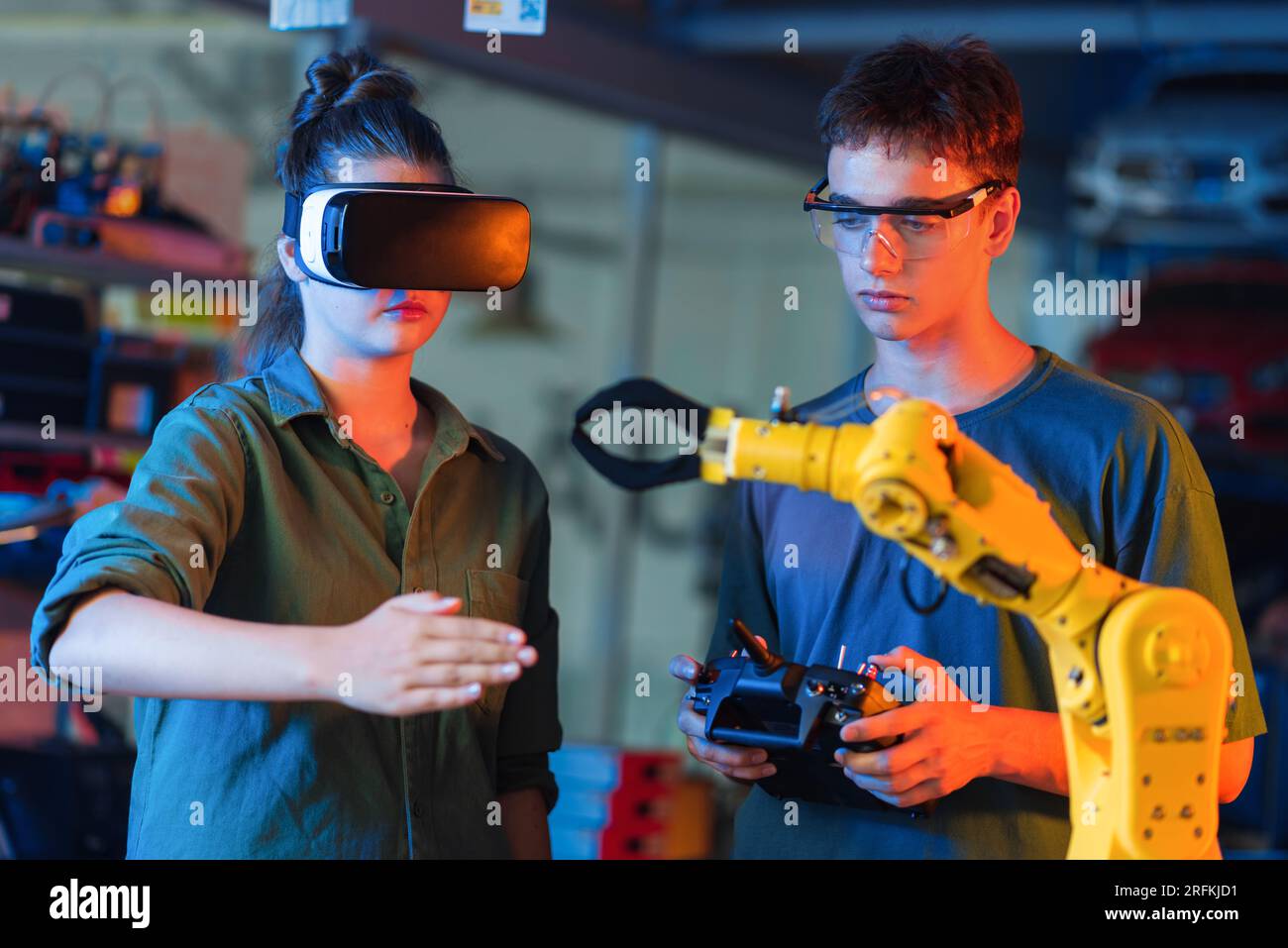 Teens doing experiments in robotics in a laboratory. Boy in protective ...