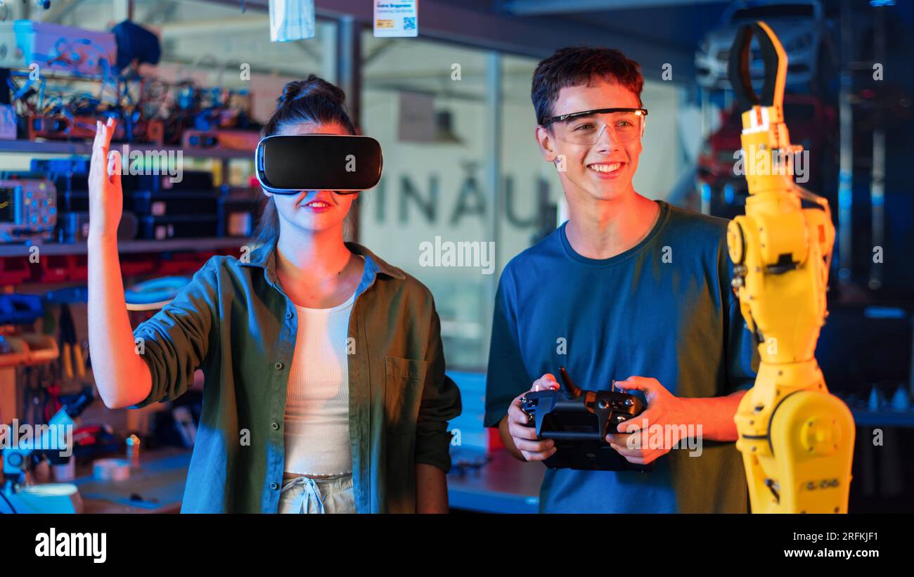 Teens doing experiments in robotics in a laboratory. Boy in protective ...
