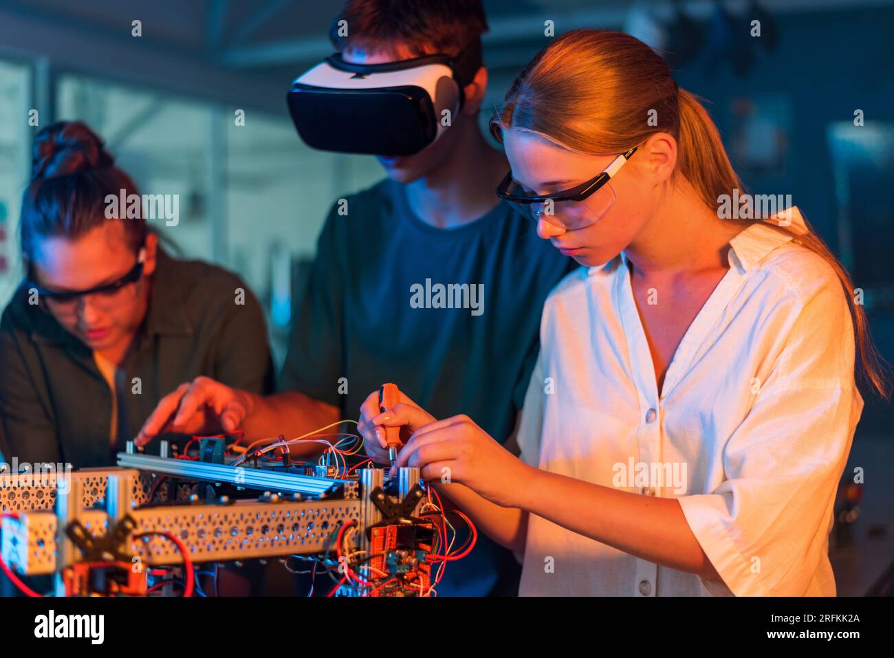 Group of teens doing experiments in robotics in a laboratory. Boy and ...