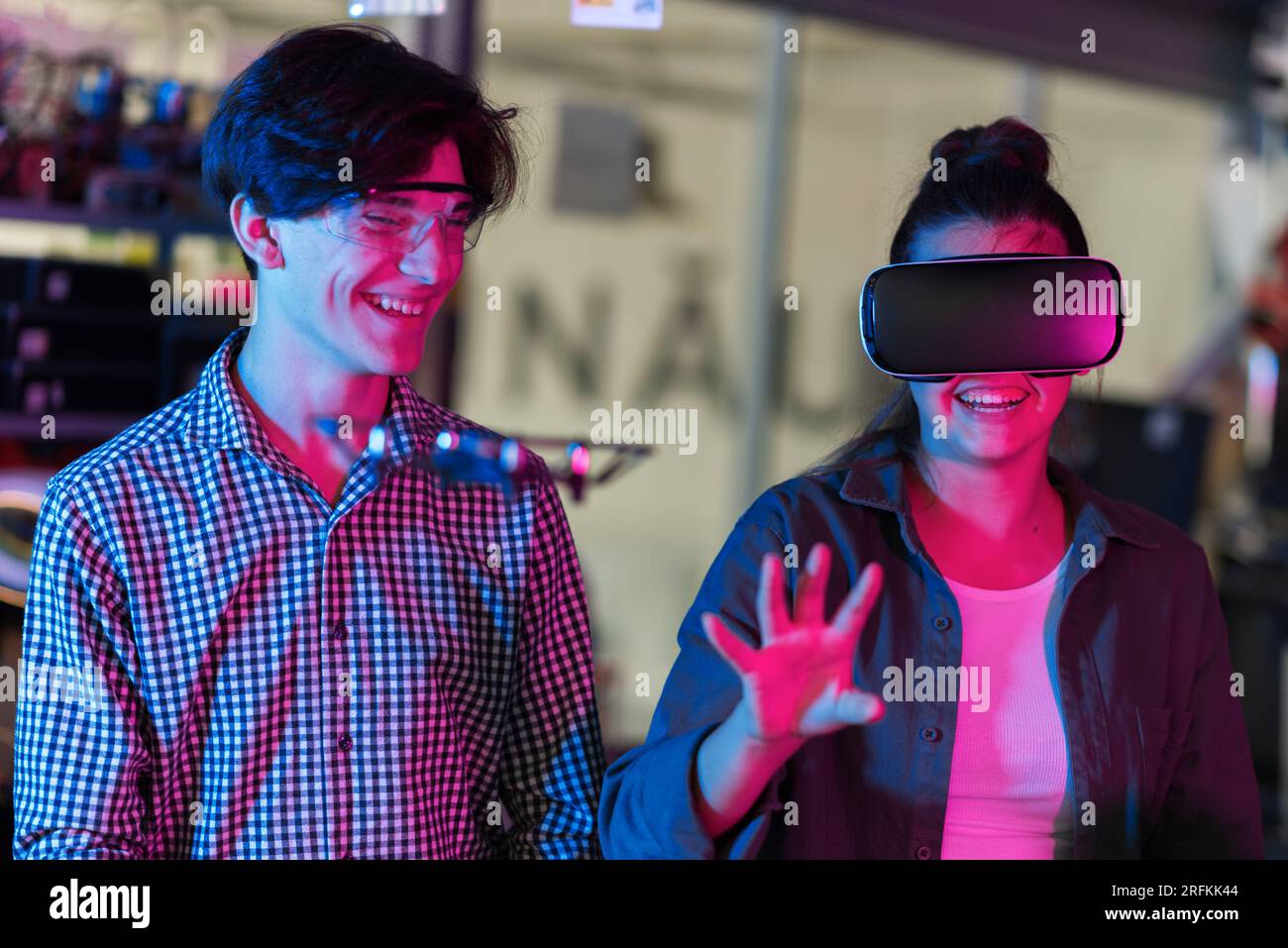 Smiling teens doing experiments in robotics in a laboratory. Boy in ...
