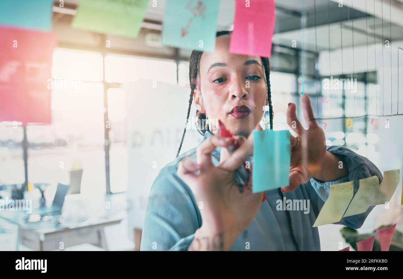 Woman at glass with ideas, thinking and sticky note for business ...