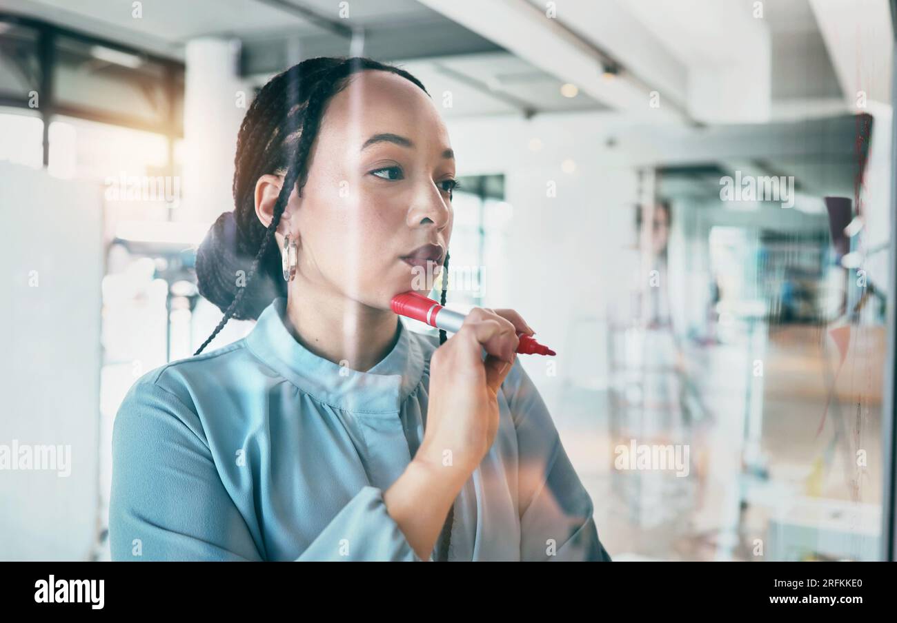 Woman at glass, thinking with ideas and pen for business planning ...