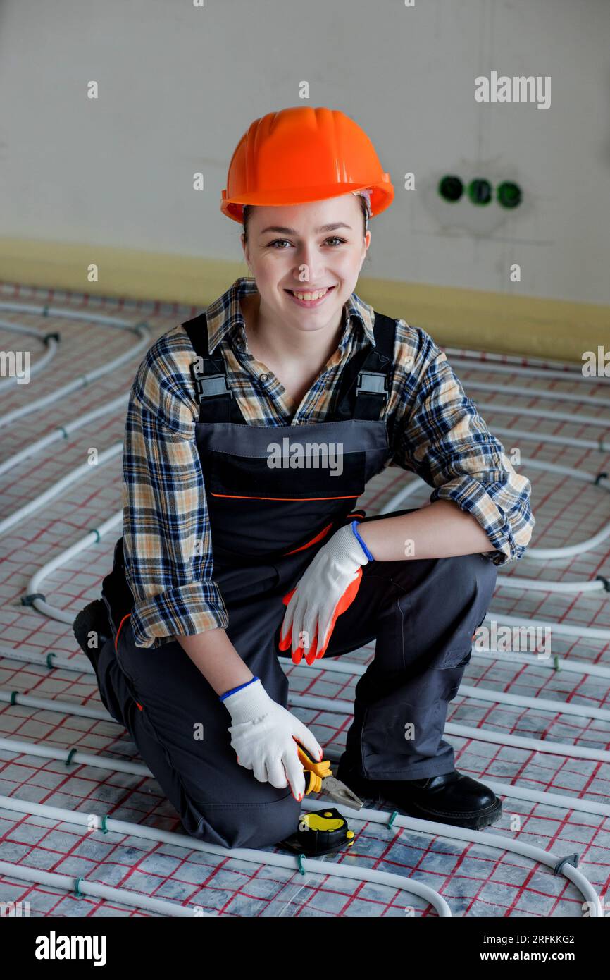 Portrait of woman worker which is installing underfloor heating system ...