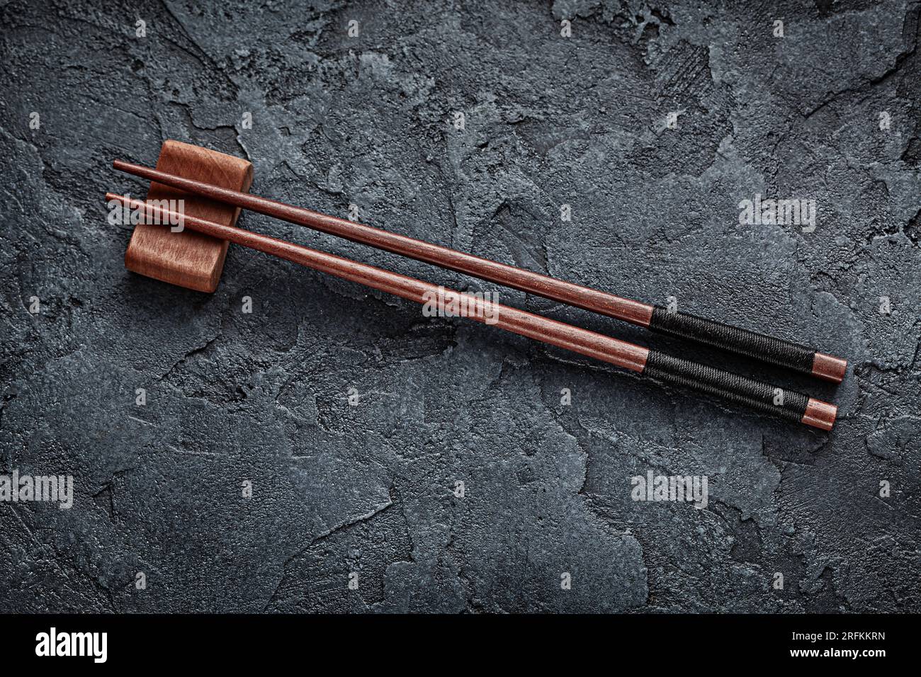 Classic Red Wooden Choppingsticks On Rest And Black Stone Background ...