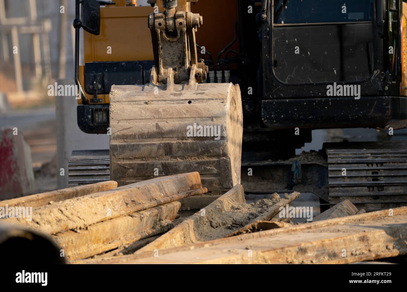 Digger parked at construction site with metal bar. Backhoe after work ...