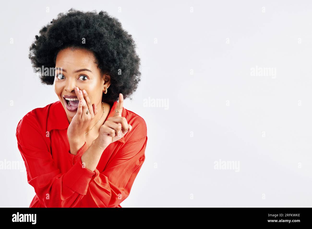 Secret, excited pointing and woman portrait with whisper in studio with ...