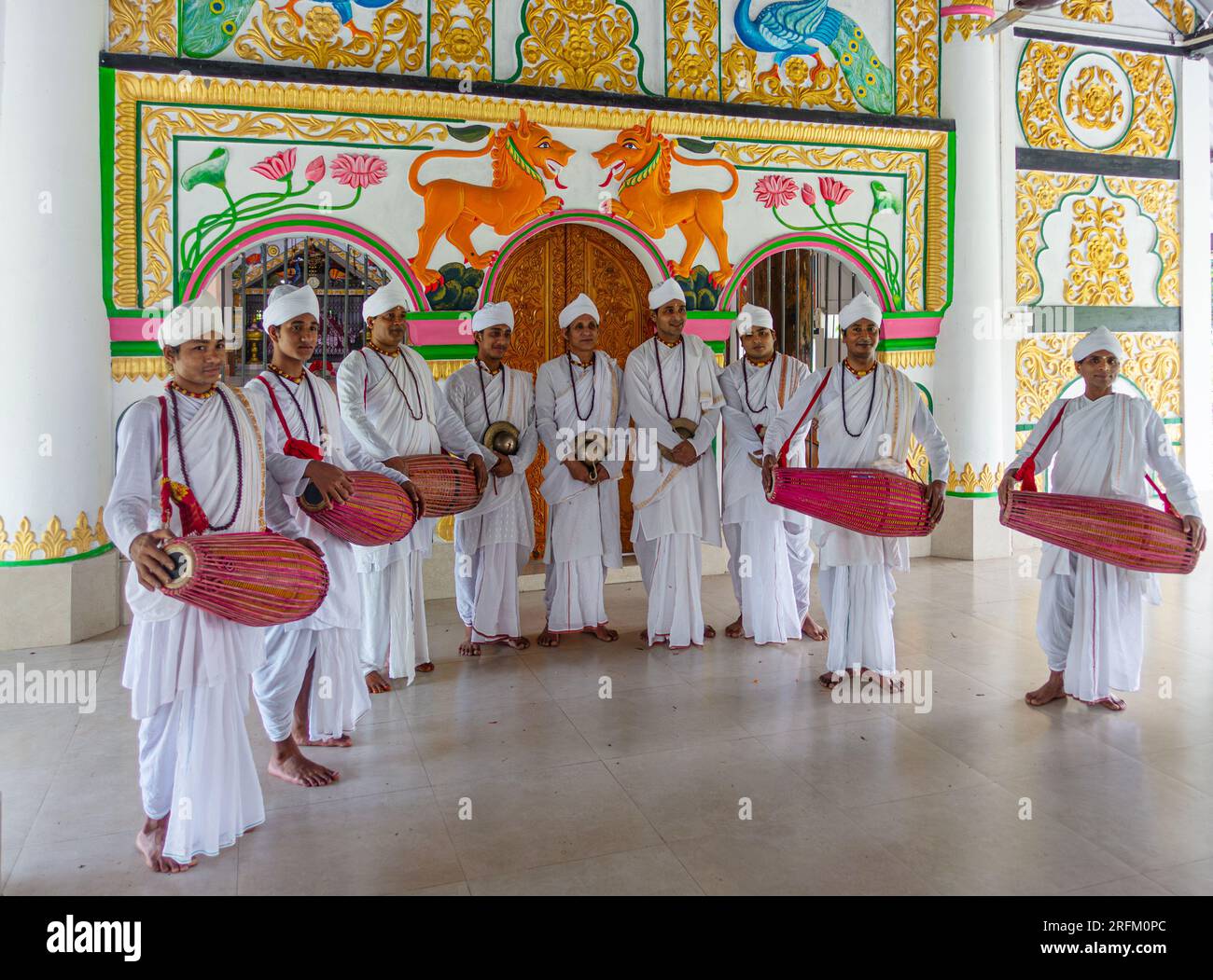 Hindu monks (bhaktis) standing with drums and cymbals in front of an ...