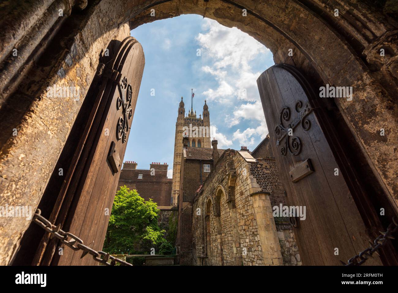 Looking through old medieval wooden doors and archway into a historic ...