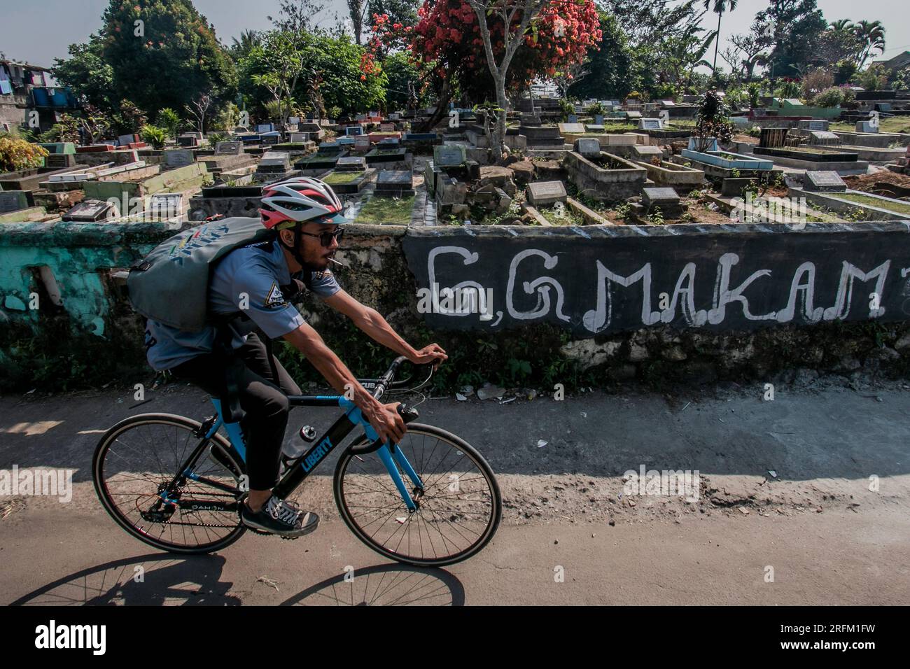 Bogor, Indonesia - August 01, 2023: Cyclists walk through a cemetery ...