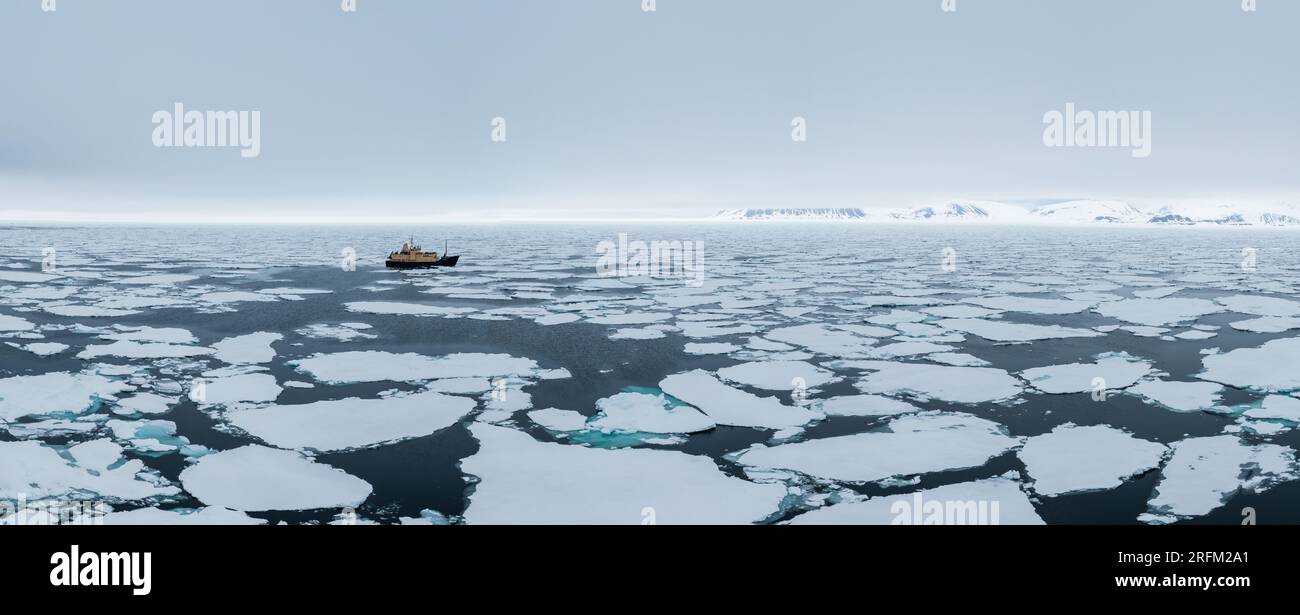 Expedition vessel cruising through sea ice in Svalbard Stock Photo - Alamy