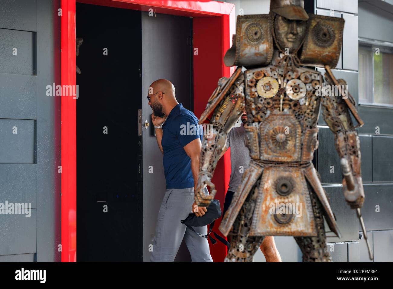 Andrew Tate walks past an artistic depiction of a samurai while ...